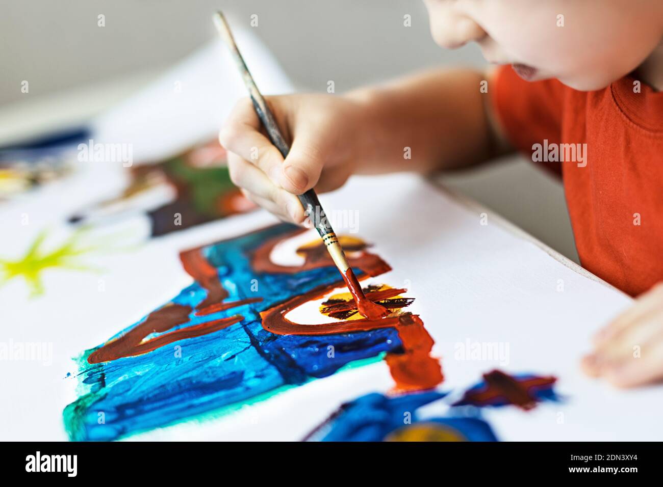 little boy draws with bright colors on white paper. children's art ...