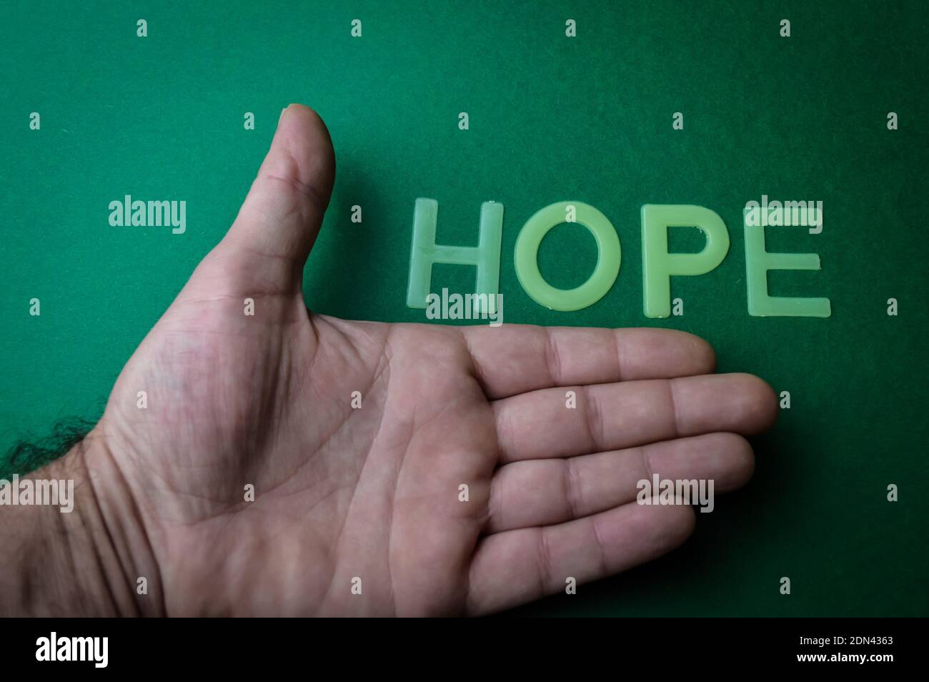 Human hand showing the word Hope written with plastic letters on green ...