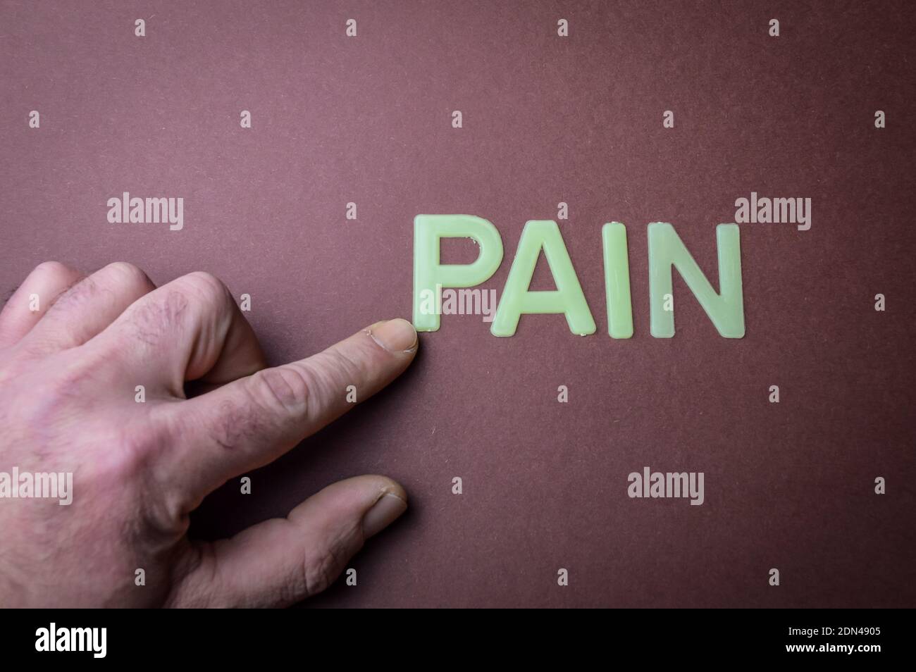 Human fingers pointing the word Pain written with plastic letters on ...