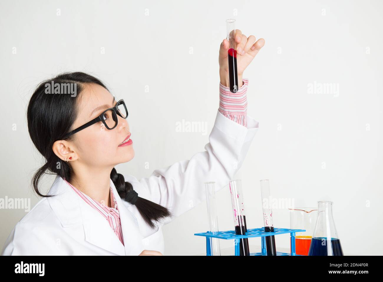 Female Scientist Examining Test Tube Against White Background Stock ...