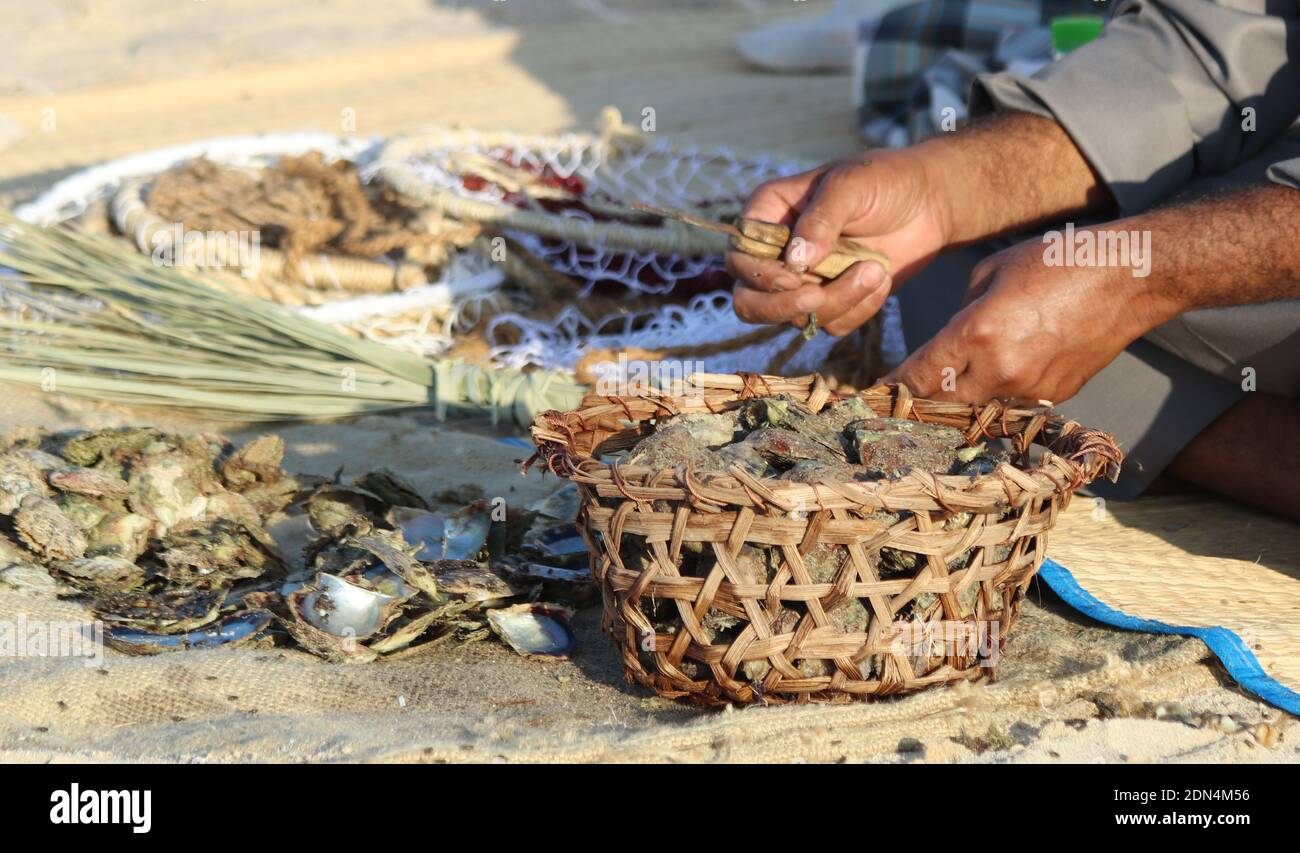 View of hands taking out pearl from oyster Stock Photo - Alamy