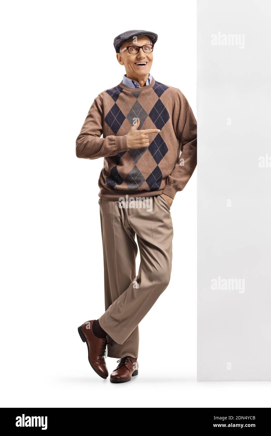 Full length portrait of an elderly man leaning on a wall and pointing ...