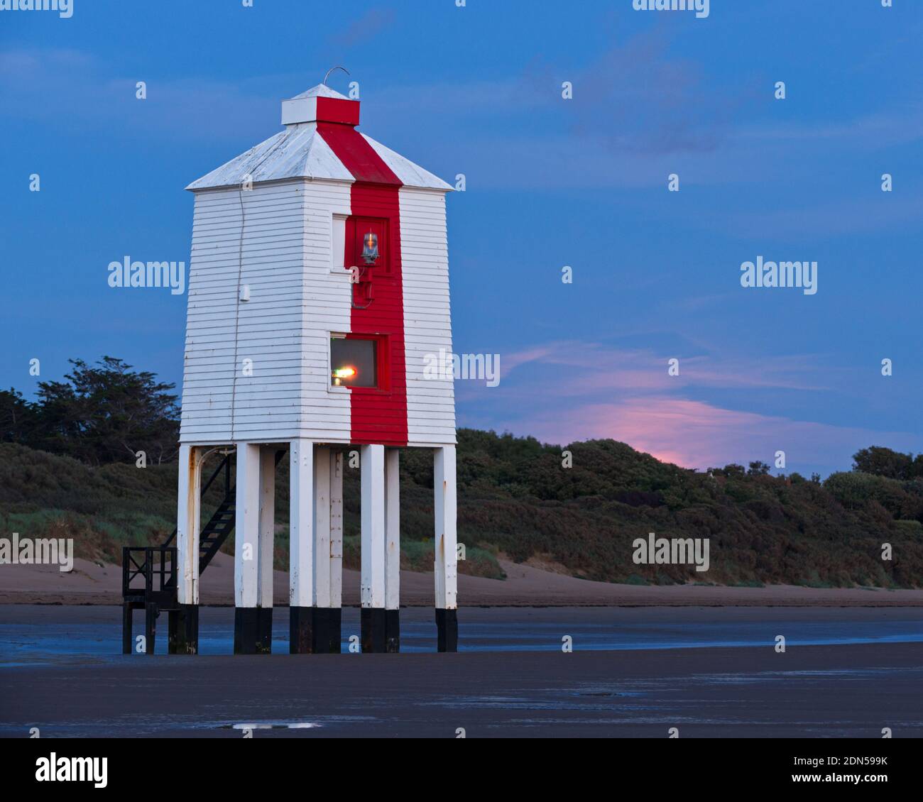the red and white wooden front (low) lighthouse on the sandy beach at ...
