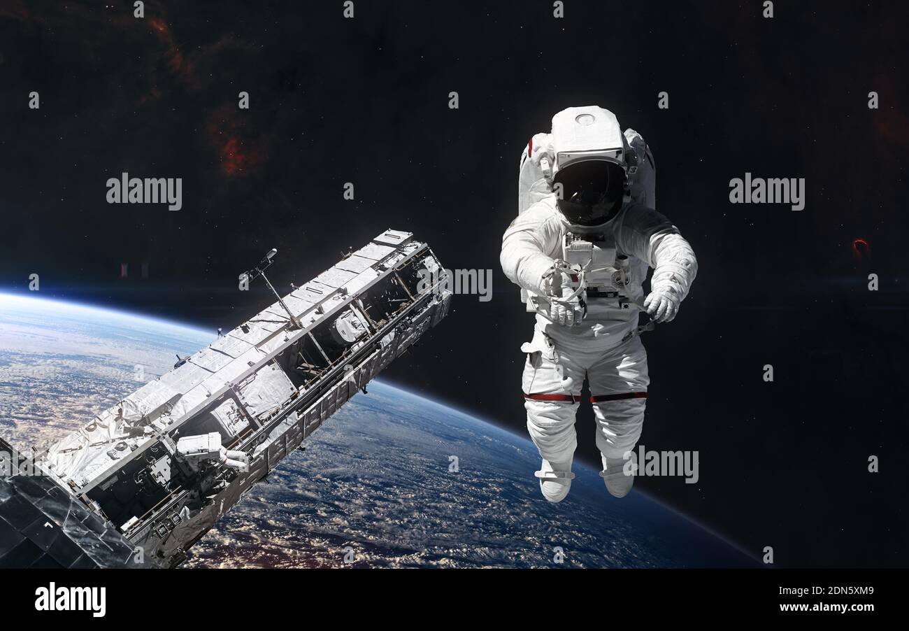 Astronaut, space station orbiting planet Earth Stock Photo - Alamy