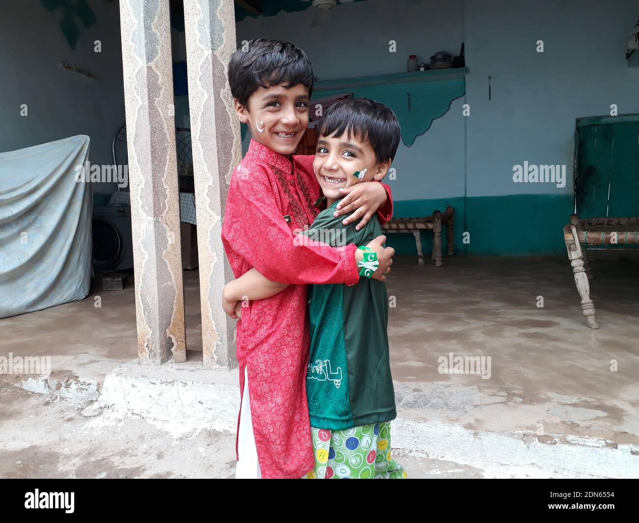 Portrait Of Smiling Brothers Embracing While Standing Against Built ...