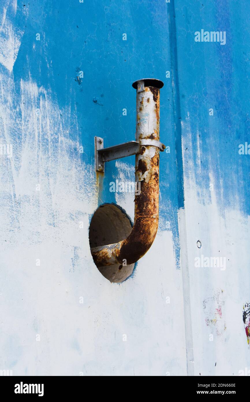 Close up of rusty metal pipe on blue wall Stock Photo - Alamy