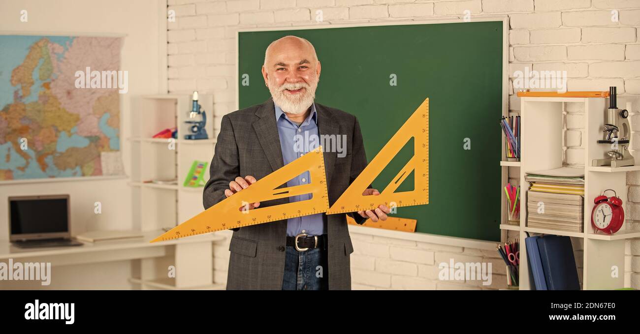 solve mathematical problems. mature man teacher use math triangle tool ...