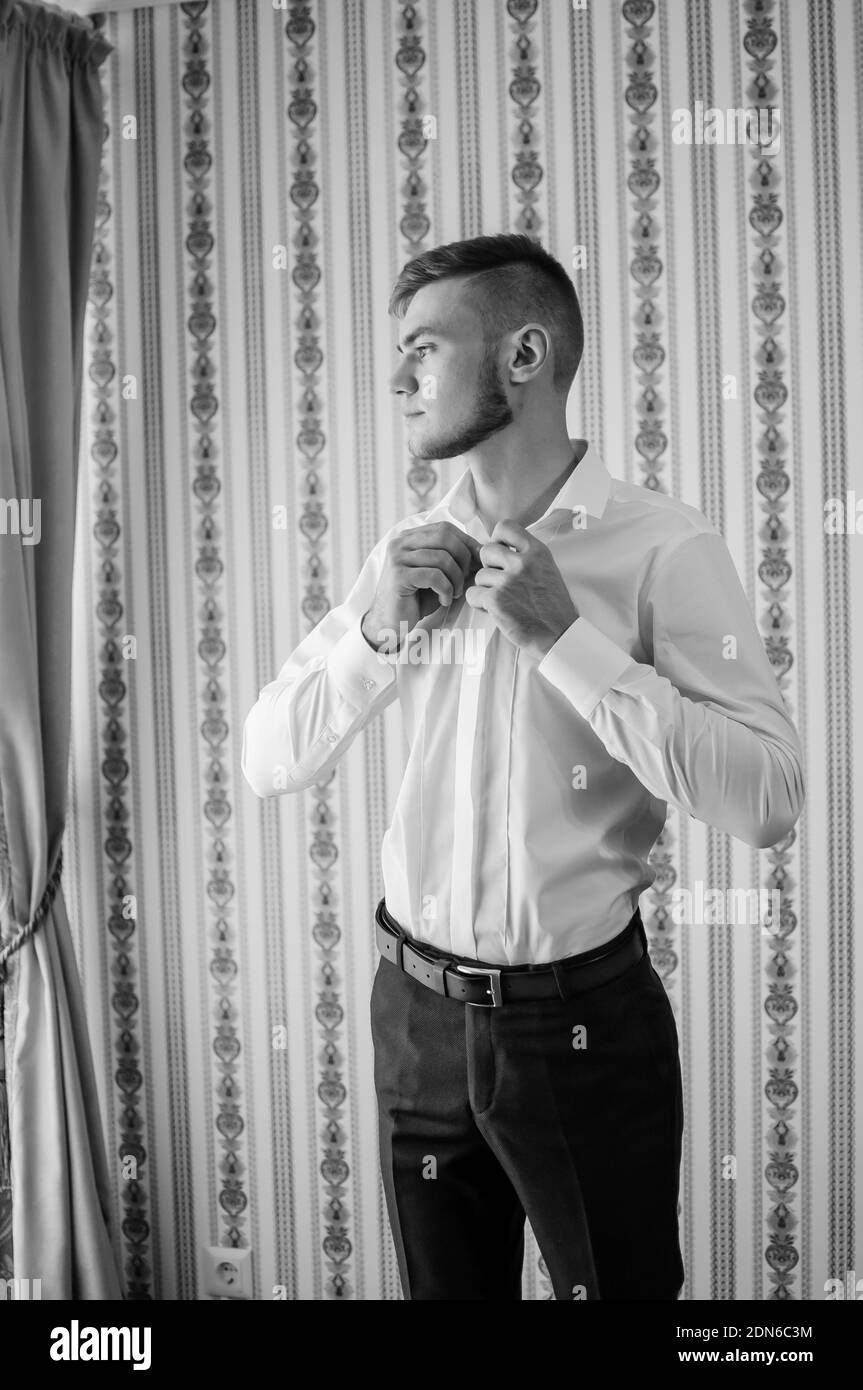 Groom's morning. The groom buttons his shirt Stock Photo - Alamy
