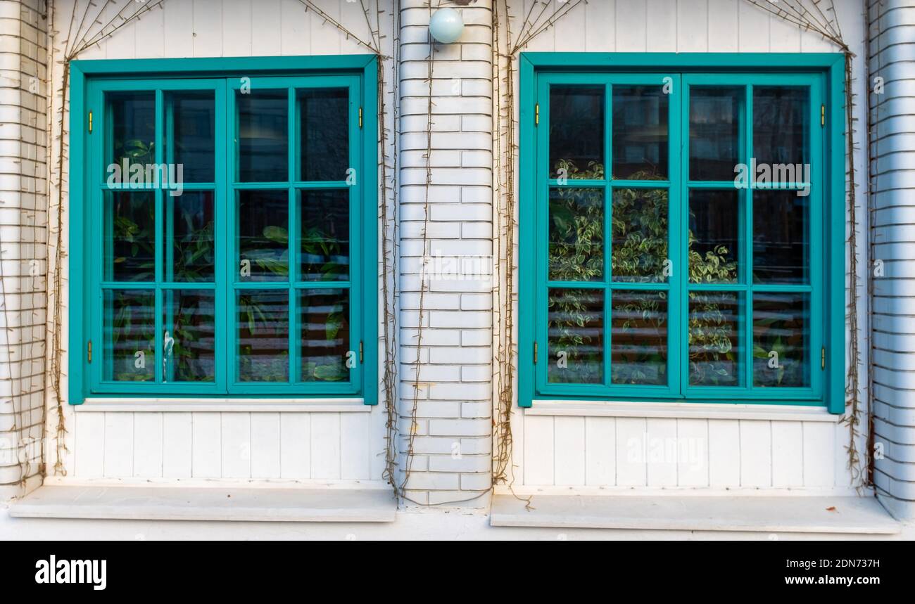 Two large turquoise windows on the veranda of a brick house Stock Photo ...