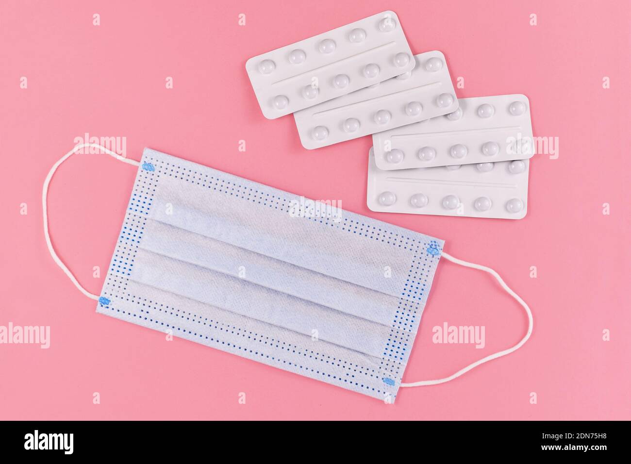 Medical face mask and pills in blisher packs on pink background Stock ...