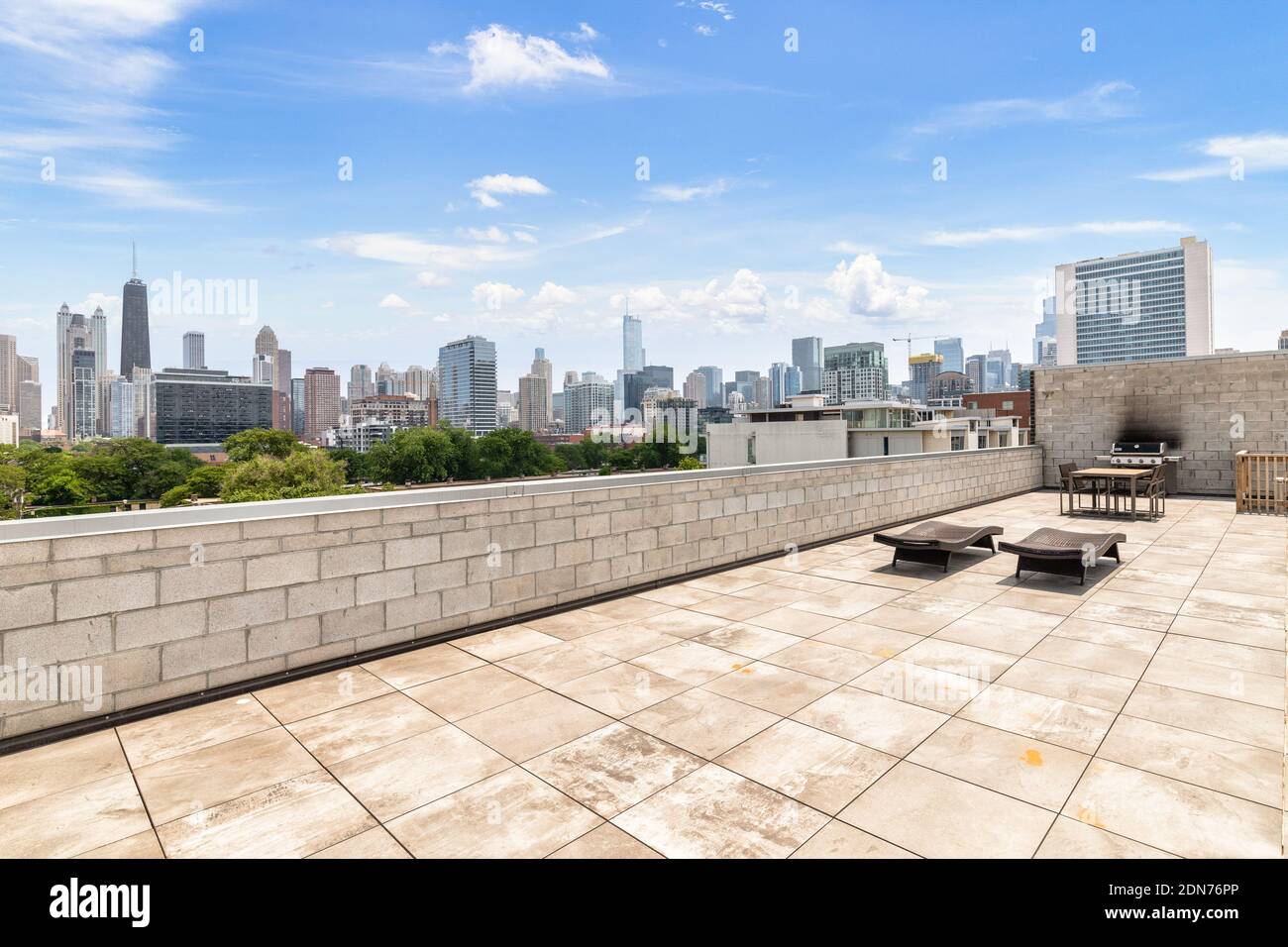 A rooftop patio of a Chicago condo building with a view of the skyline ...