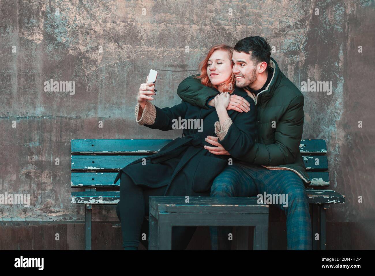 Cheerful Emotional Young Couple Sitting on the Bench and Making Selfie ...