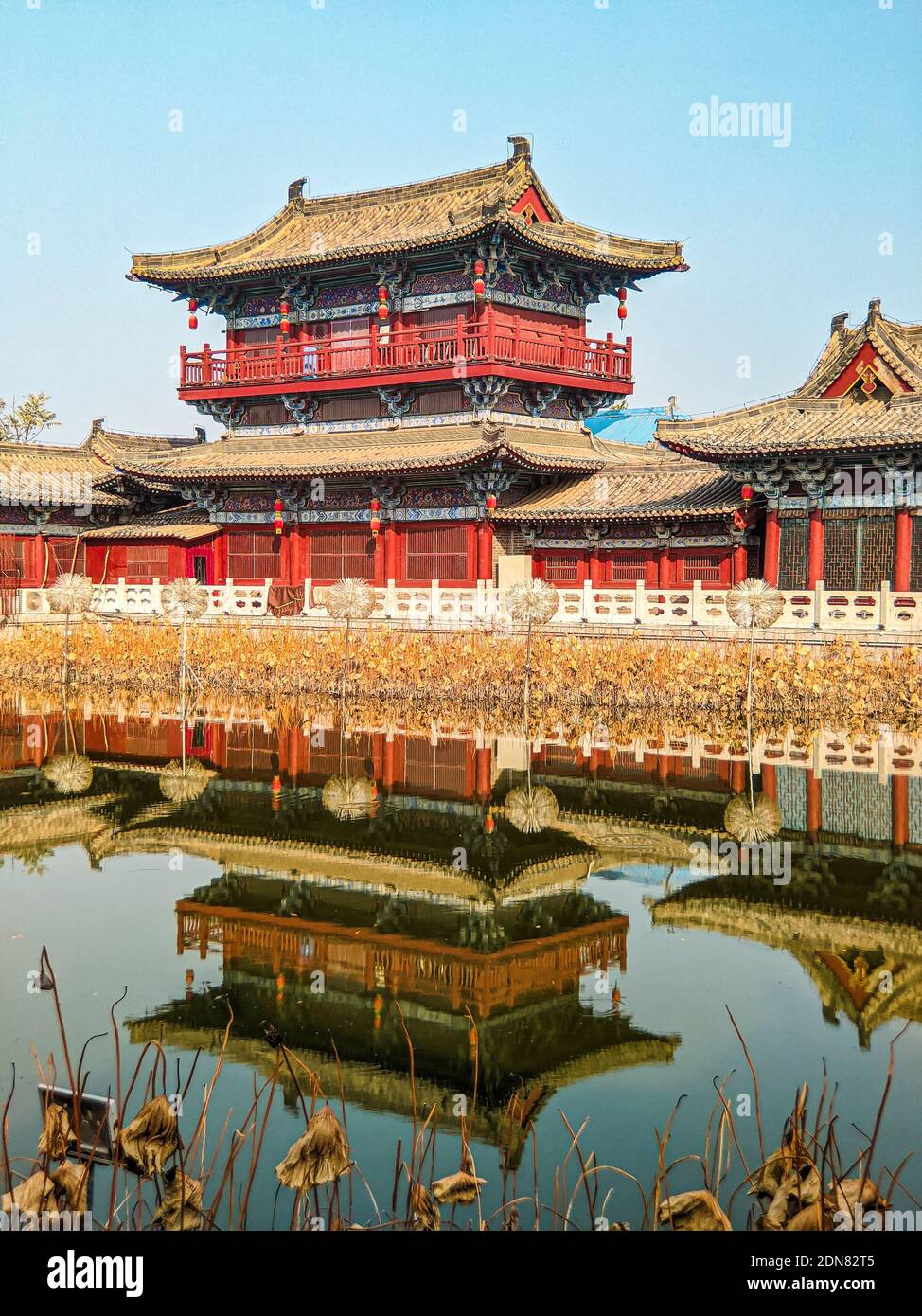 A historic Buddhist temple with a zen garden reflecting in a lake in ...