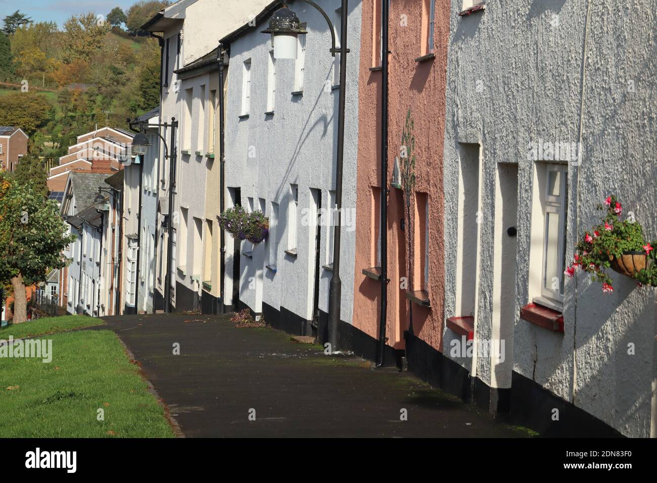 A colourful terrace of cottages sloping downhill in Bradninch, Devon ...