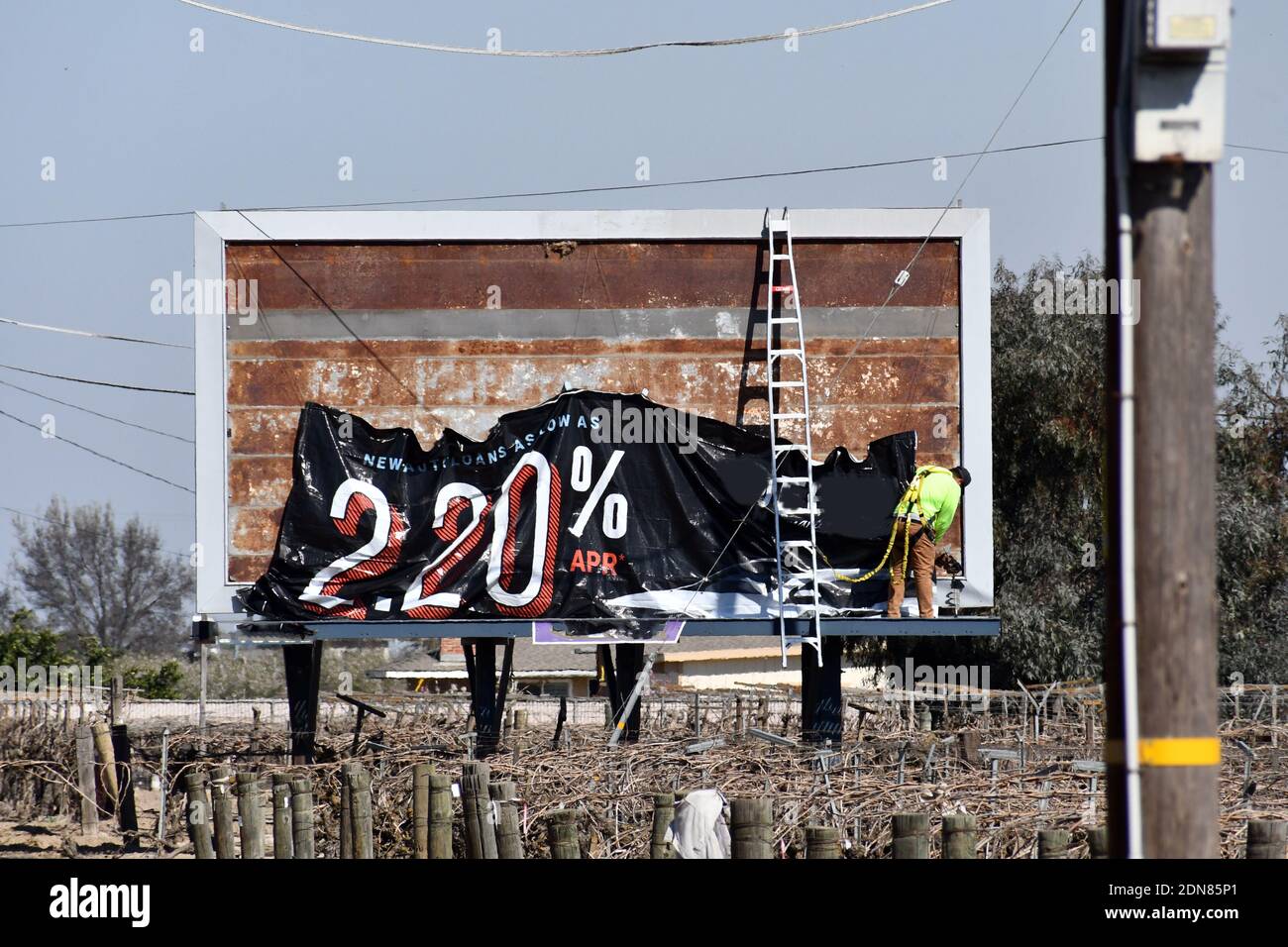 A worker taking off the banner from the billboard Stock Photo - Alamy