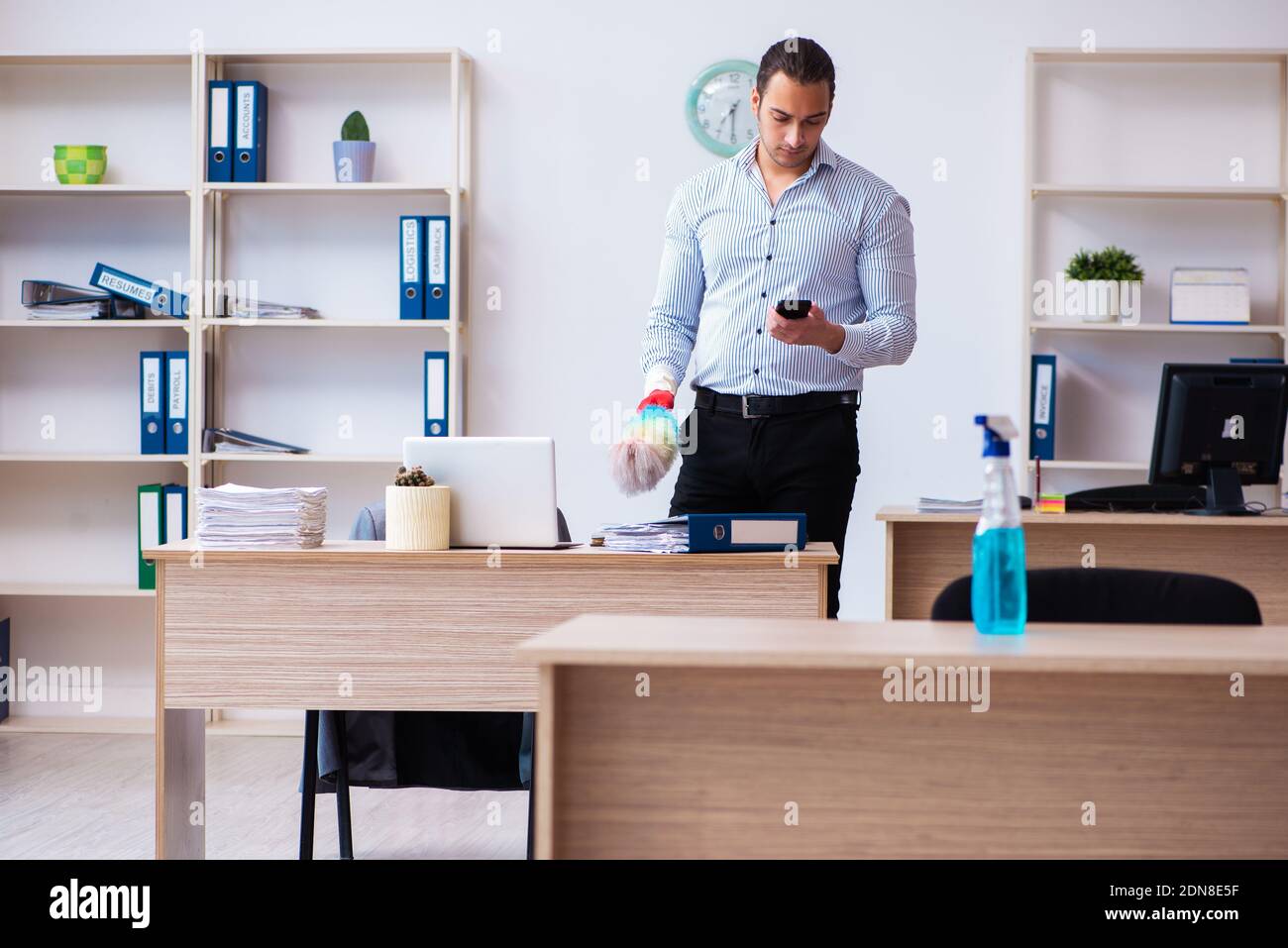 Young employee businessman cleaning office during pandemic Stock Photo - Alamy