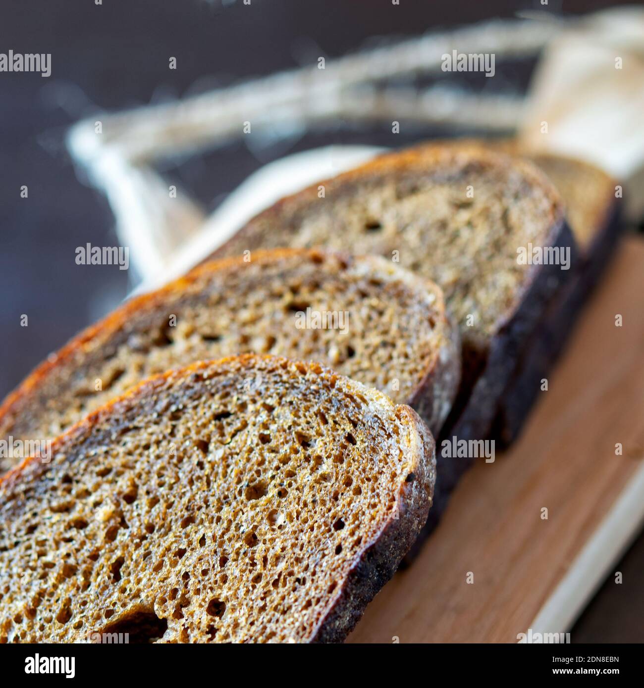 Slices of fresh grey bread on the wooden natural board. Healthy food ...