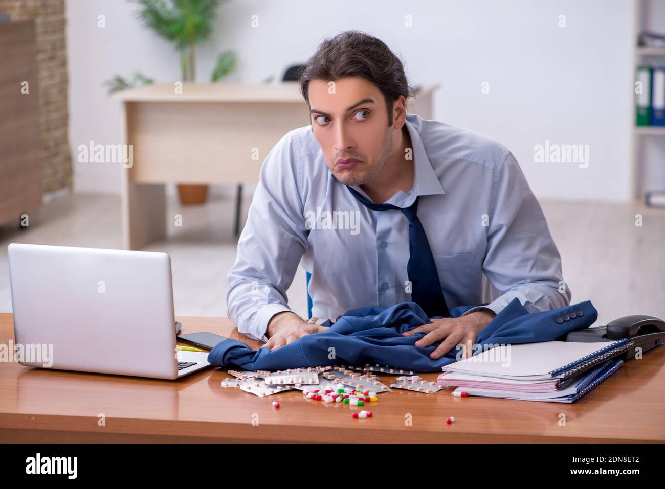 Sick male employee suffering at workplace Stock Photo - Alamy