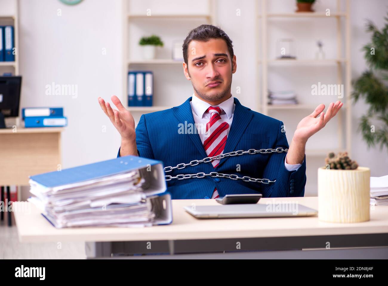 Chained employee working in the office Stock Photo - Alamy