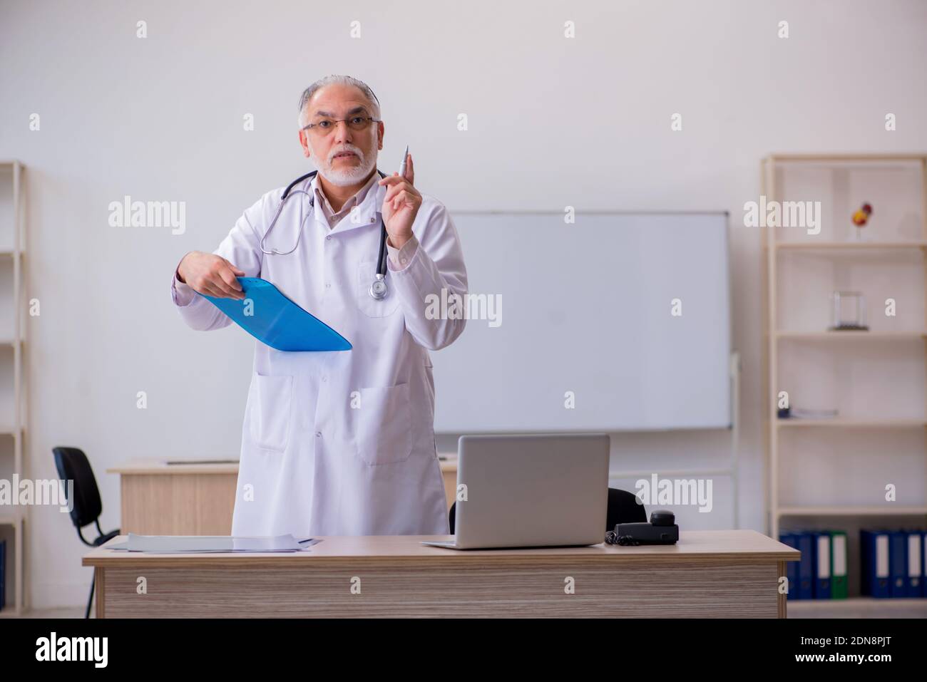 Old doctor working in the clinic Stock Photo - Alamy