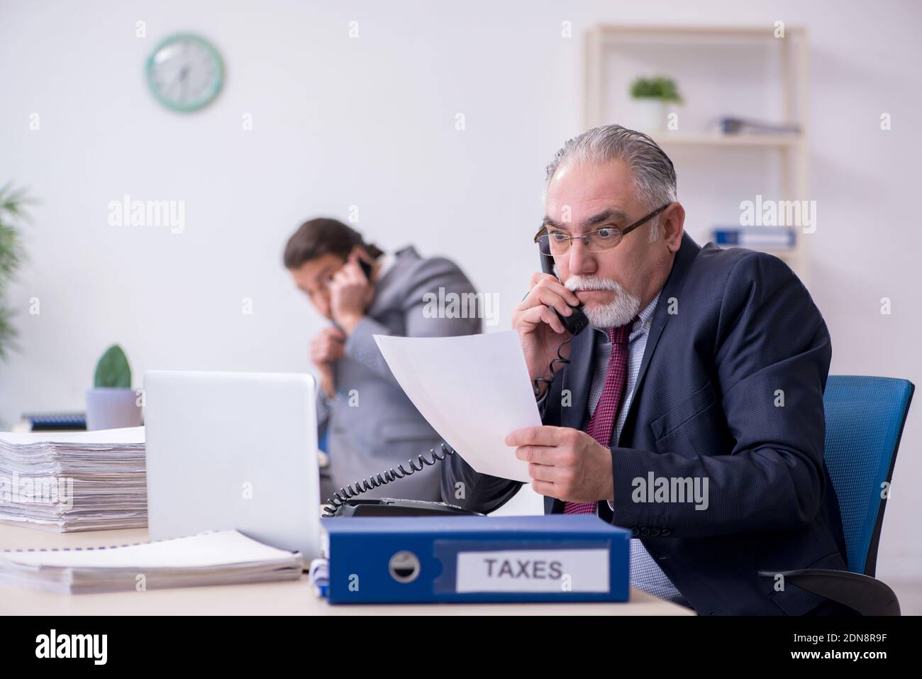Old boss and his assistant working in the office Stock Photo - Alamy