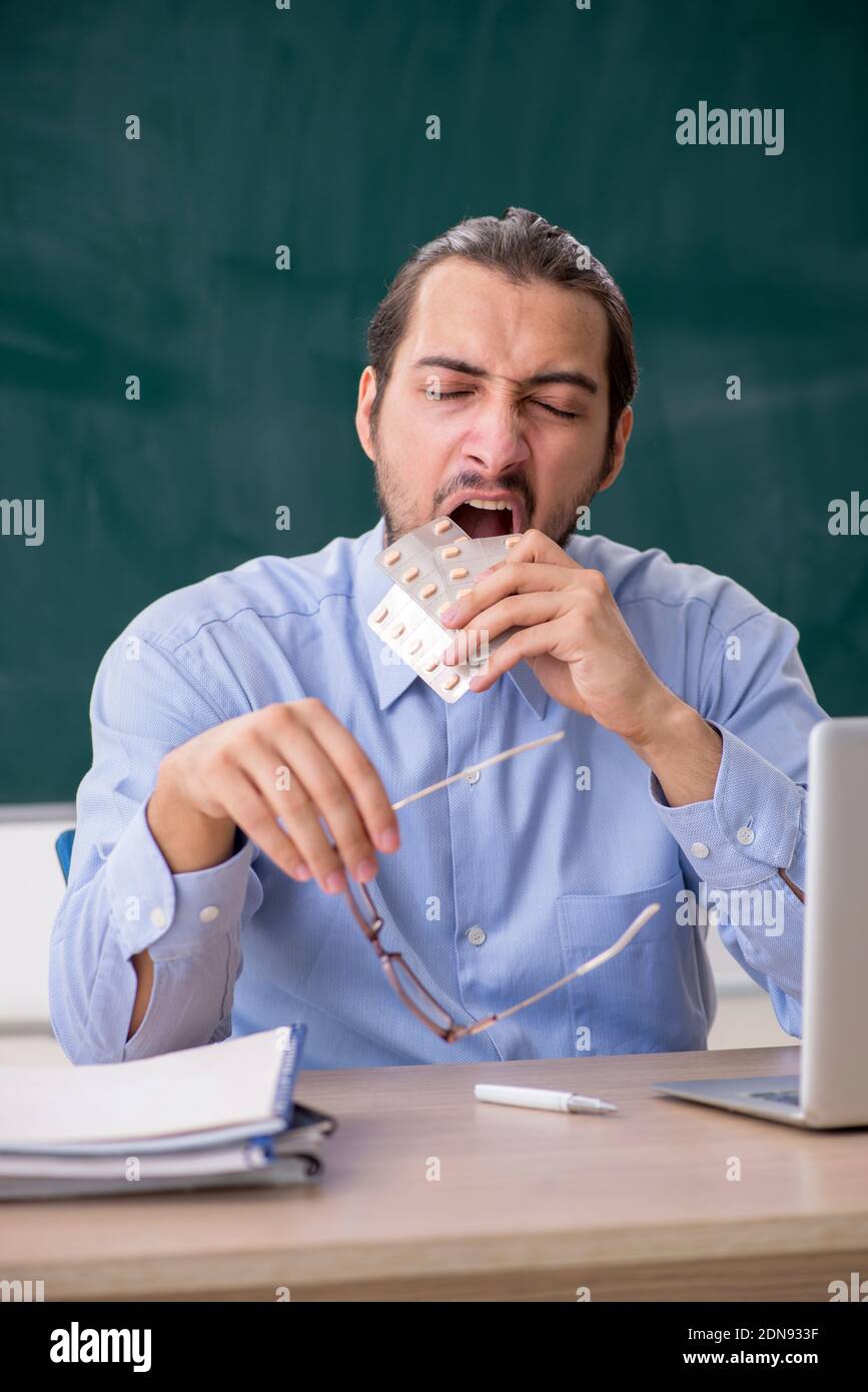 Young sick teacher in the classroom Stock Photo - Alamy