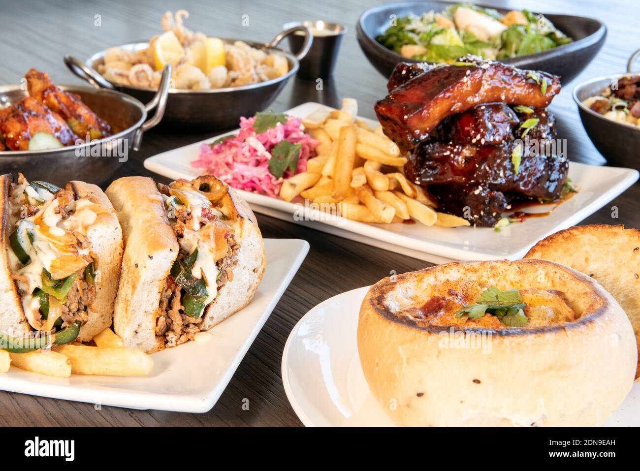 Full table of restaurant variety of food including bread bowl clam ...