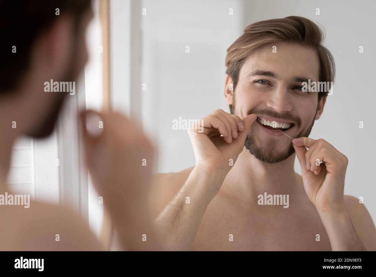 Happy millennial man cleaning teeth with dental floss Stock Photo - Alamy