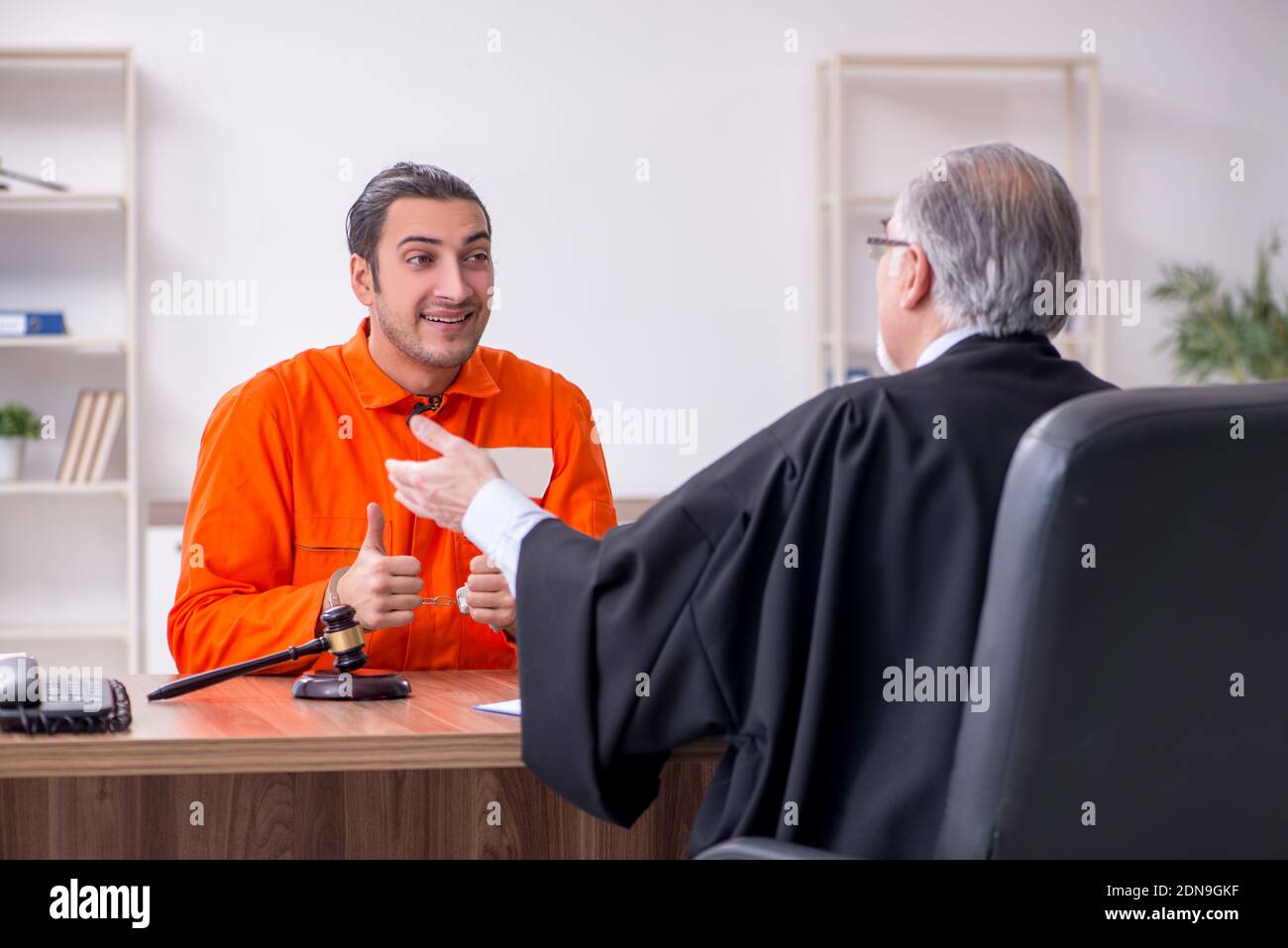 Old judge meeting with young captive in courthouse Stock Photo - Alamy