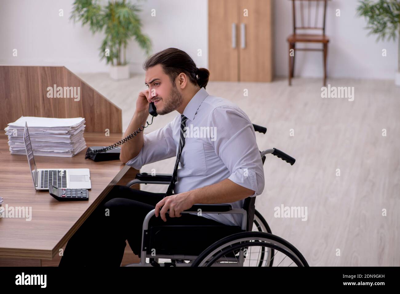 Young disabled employee suffering at the workplace Stock Photo - Alamy
