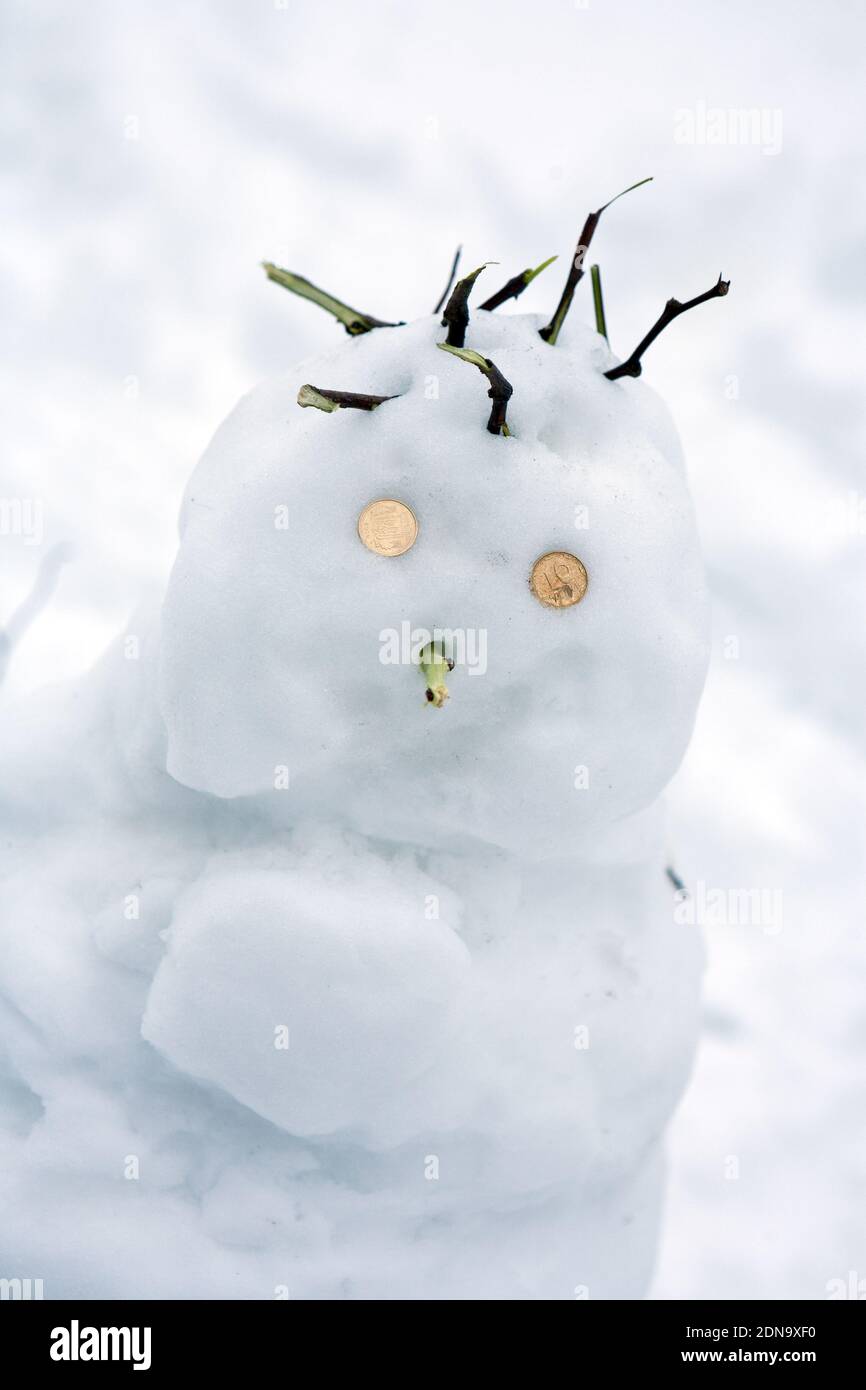 Snowman on a background of snow with coins place the eye Stock Photo ...