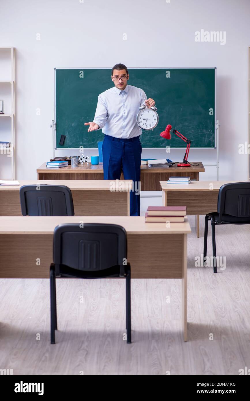 Young teacher in front of green board Stock Photo - Alamy