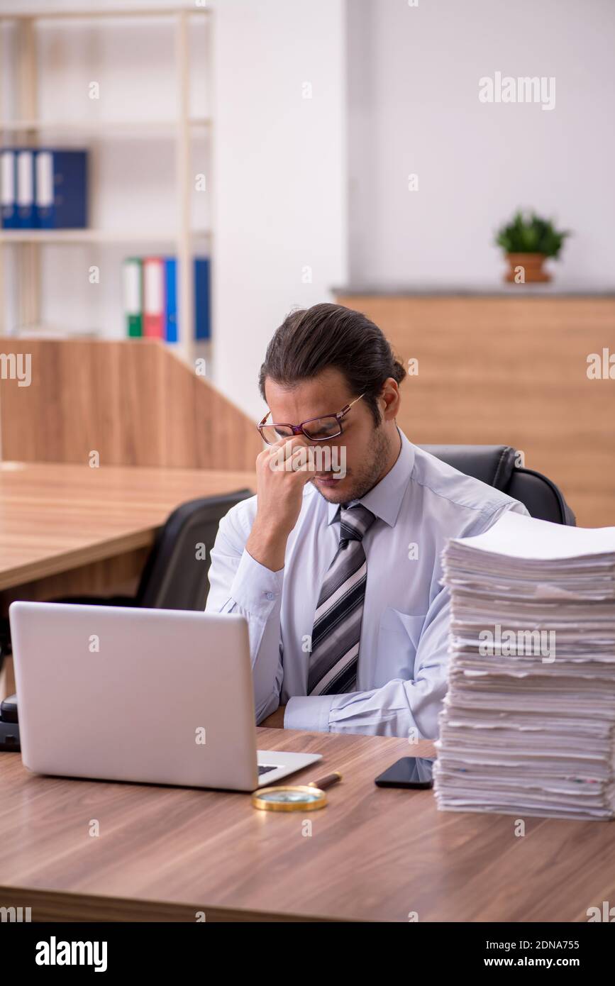 Young employee unhappy with excessive work in the office Stock Photo ...