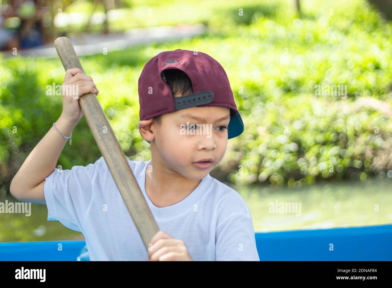 Boy Rowing Boat In Water Stock Photo - Alamy