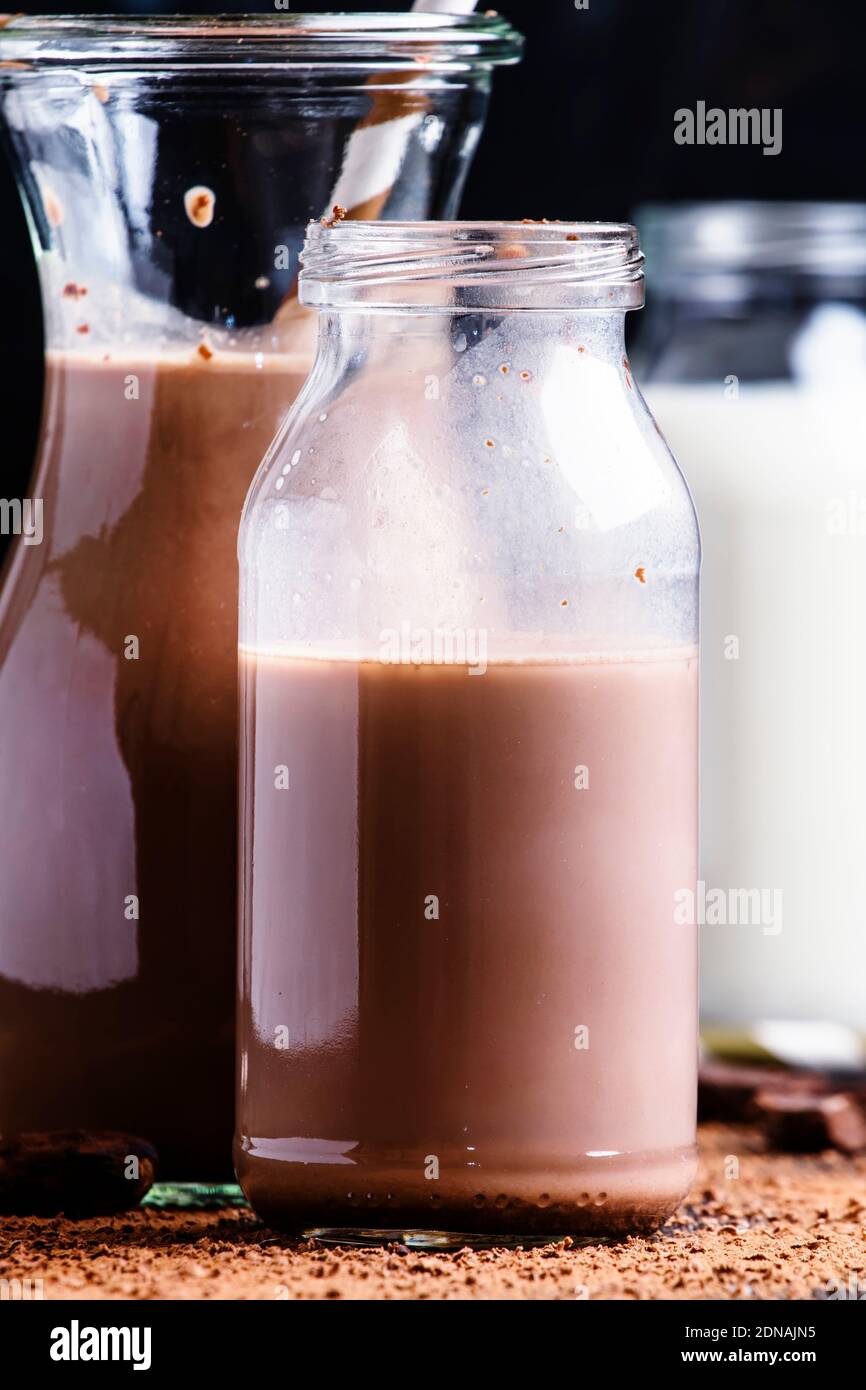 Cocoa or milk with chocolate, glass bottles, changing background ...