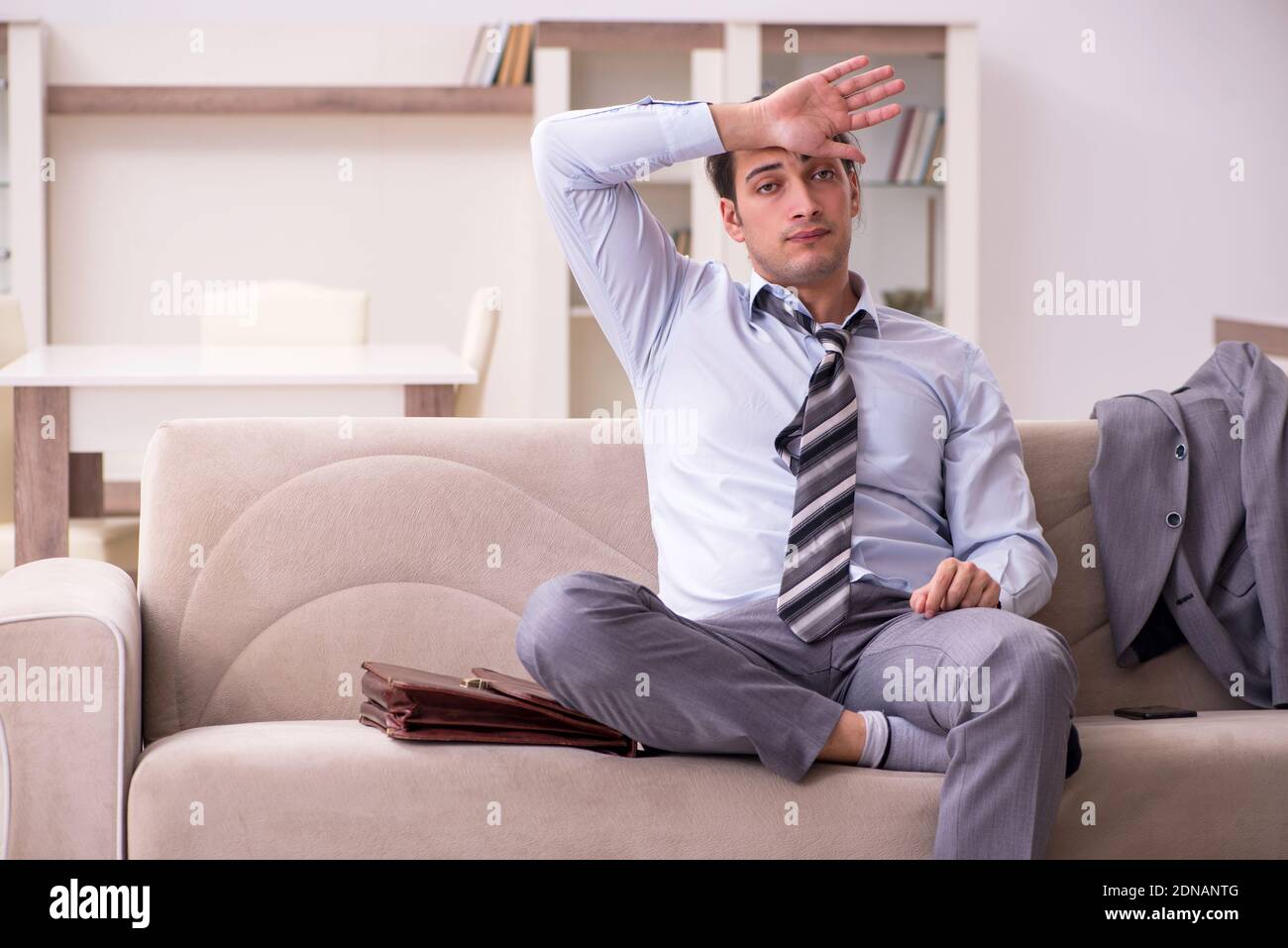 Tired businessman coming home after working day Stock Photo - Alamy