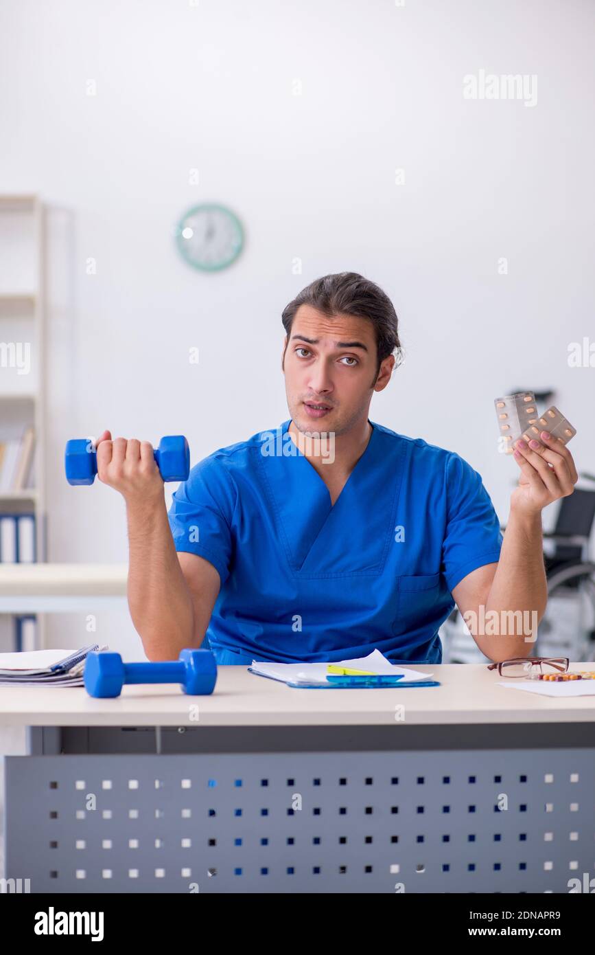 Young doctor physiotherapist doing sport exercises Stock Photo - Alamy