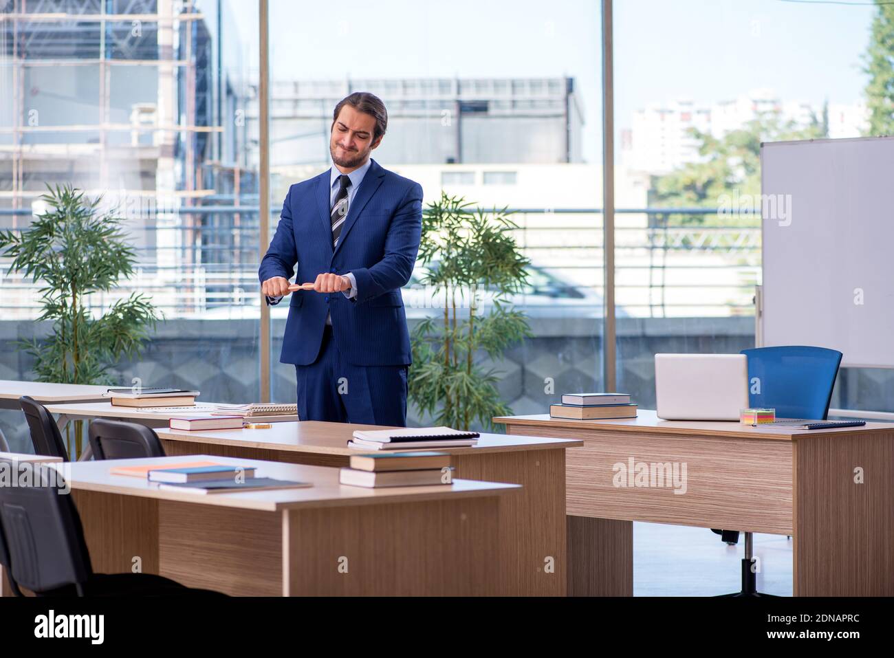 Young teacher in suit in the classroom Stock Photo - Alamy