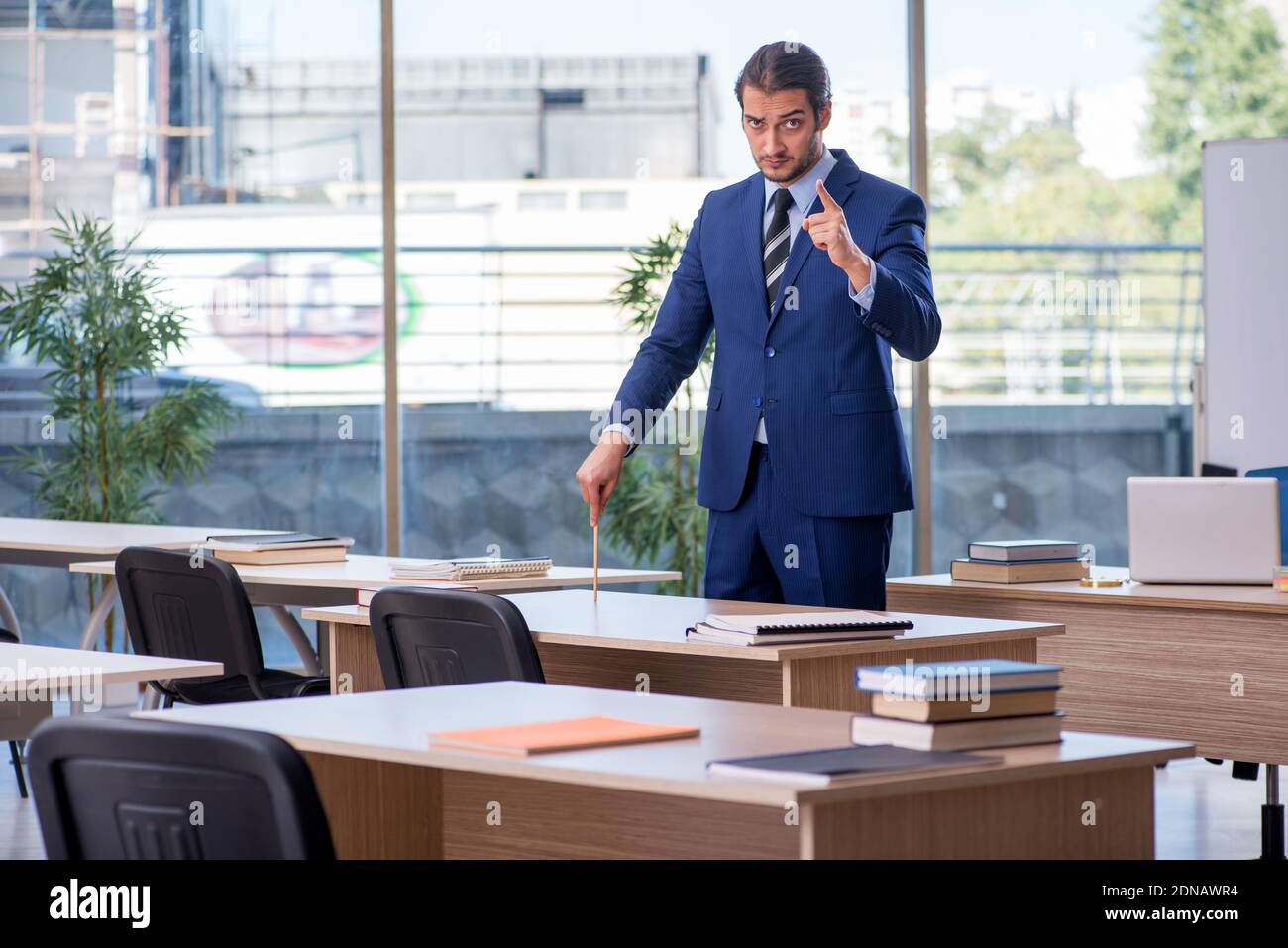 Young teacher in suit in the classroom Stock Photo - Alamy