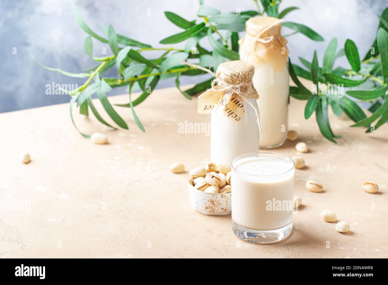 Vegan Pistachio nut milk in bottles, closeup, beige table background ...