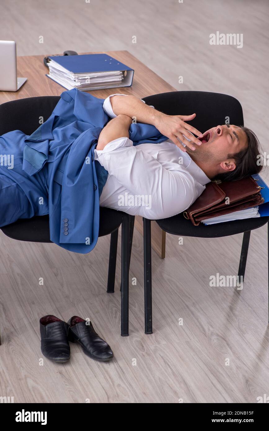Young employee sleeping in the office on chairs Stock Photo - Alamy