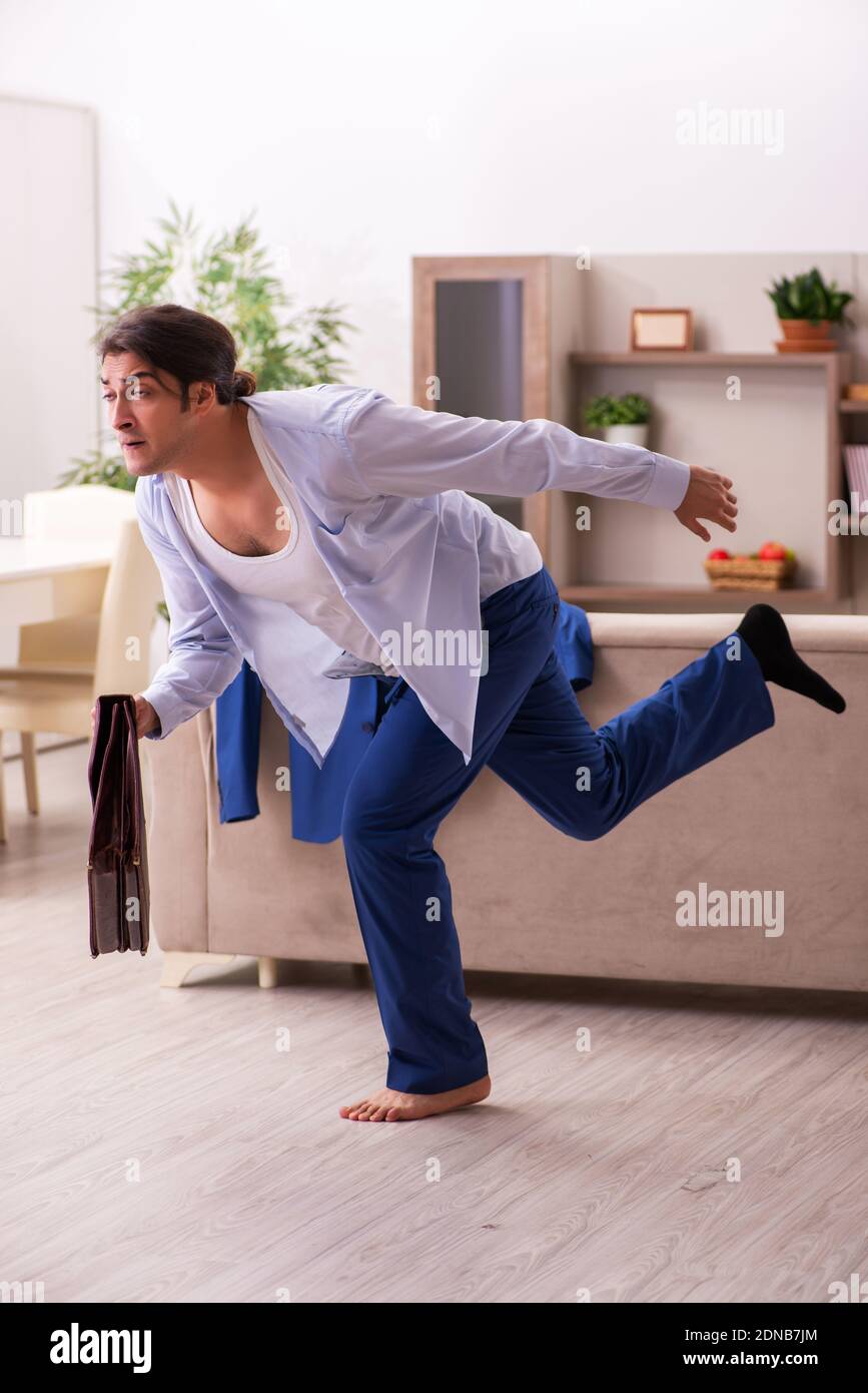 Young employee getting up late at home Stock Photo - Alamy