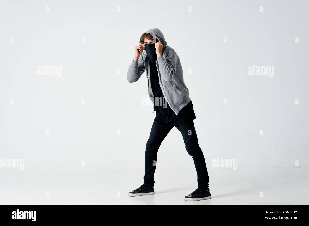 male hacker in a gray sweater stealing black mask on his face Stock ...