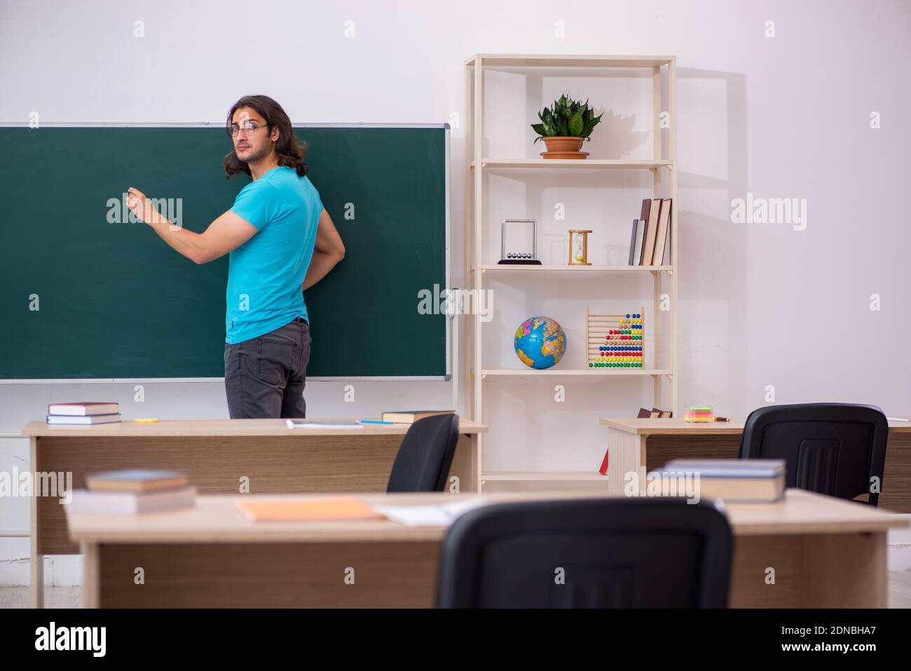 Young student in front of green board Stock Photo - Alamy