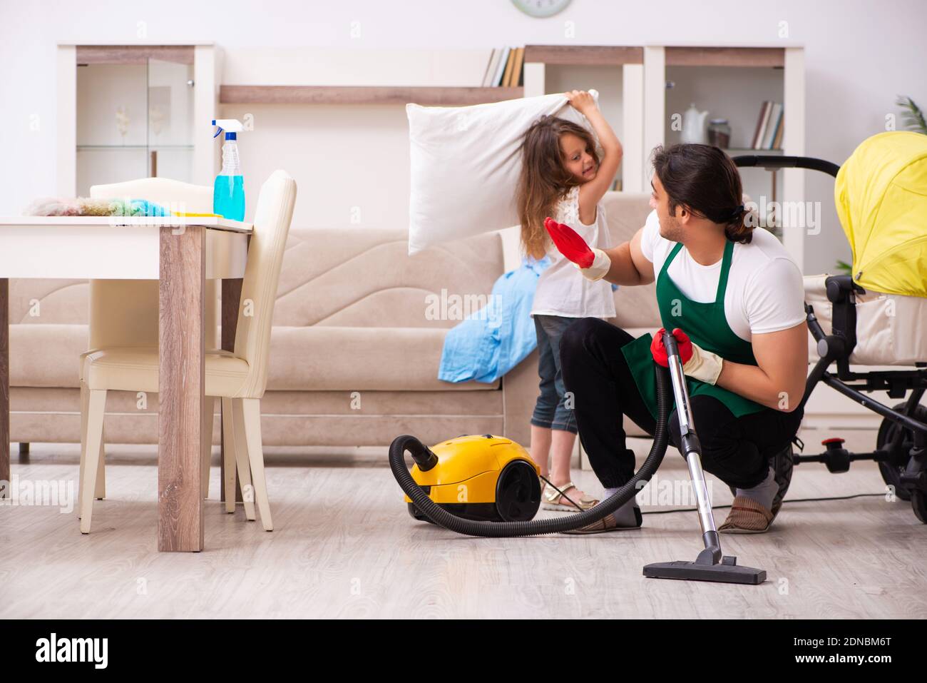 Young contractor cleaning the house with his small daughter Stock Photo ...