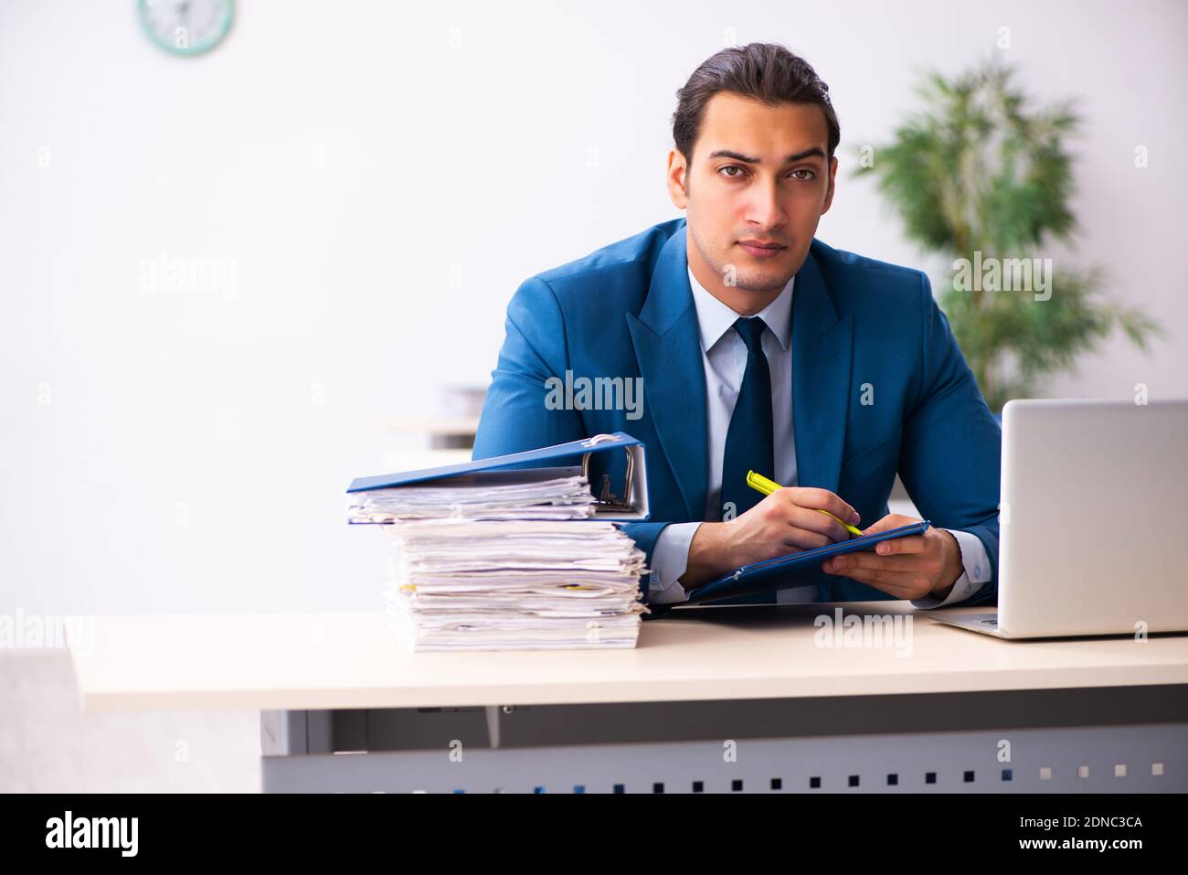 Young male employee taking notes in the office Stock Photo - Alamy