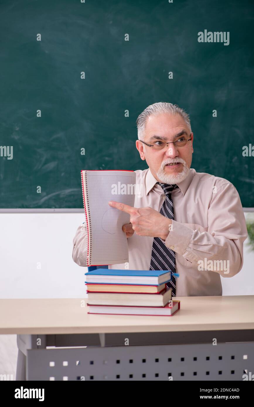 Old experienced teacher in the classroom Stock Photo - Alamy
