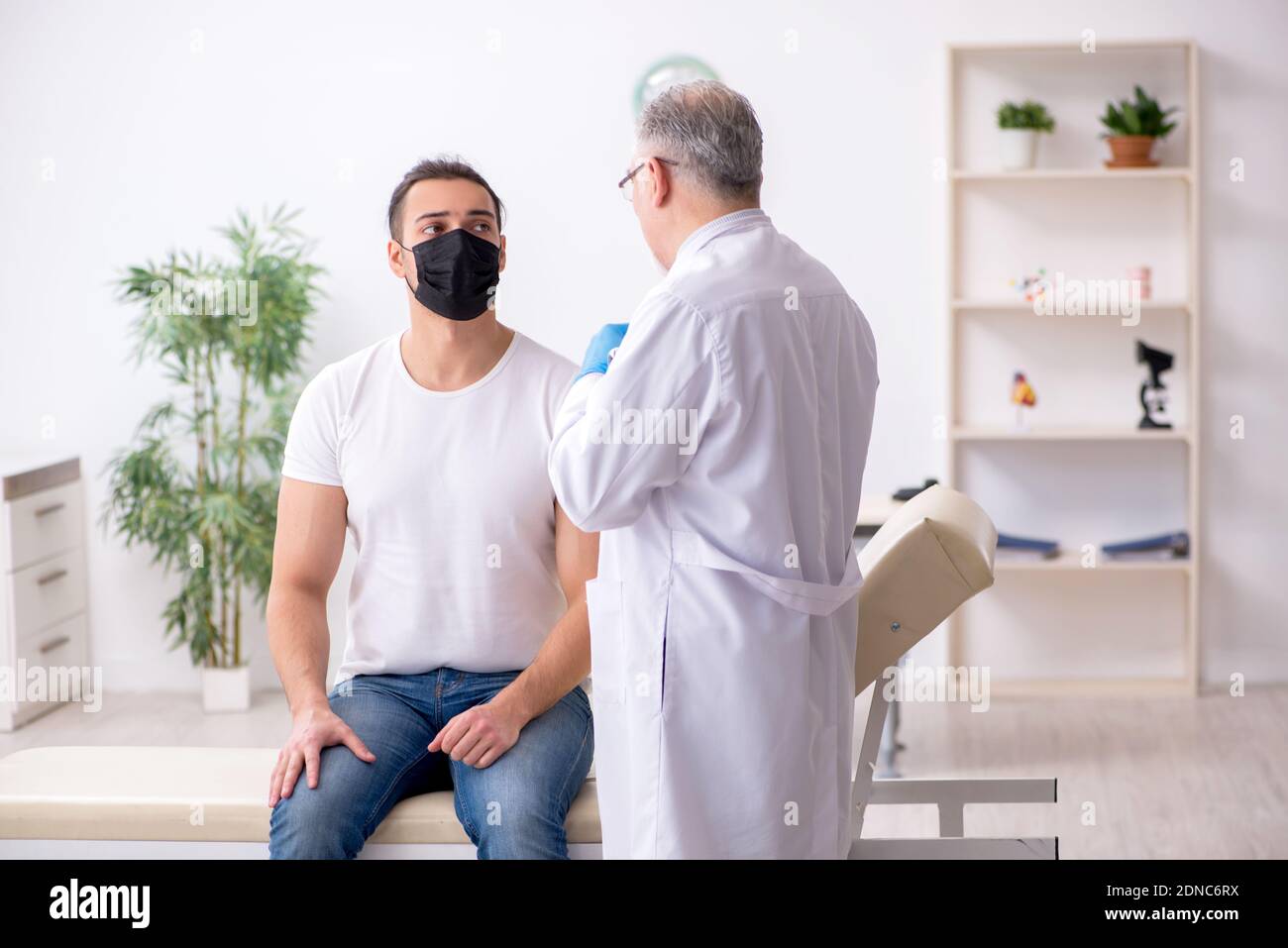 Young man visiting experienced doctor Stock Photo - Alamy