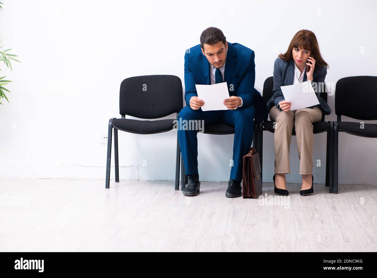 Businessman and businesswoman waiting for an interview at hall Stock ...