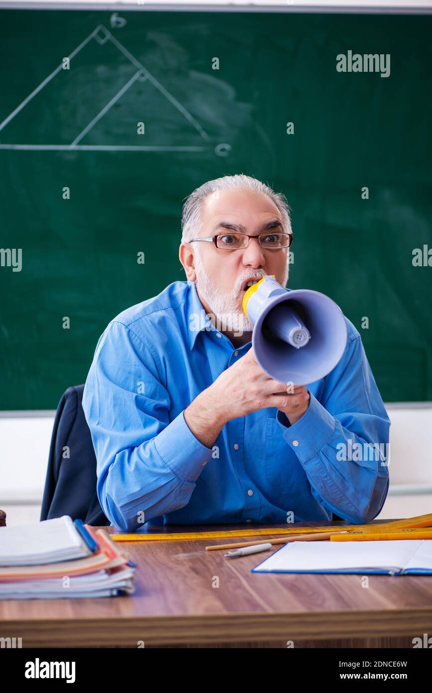 Angry male math teacher holding megaphone Stock Photo - Alamy